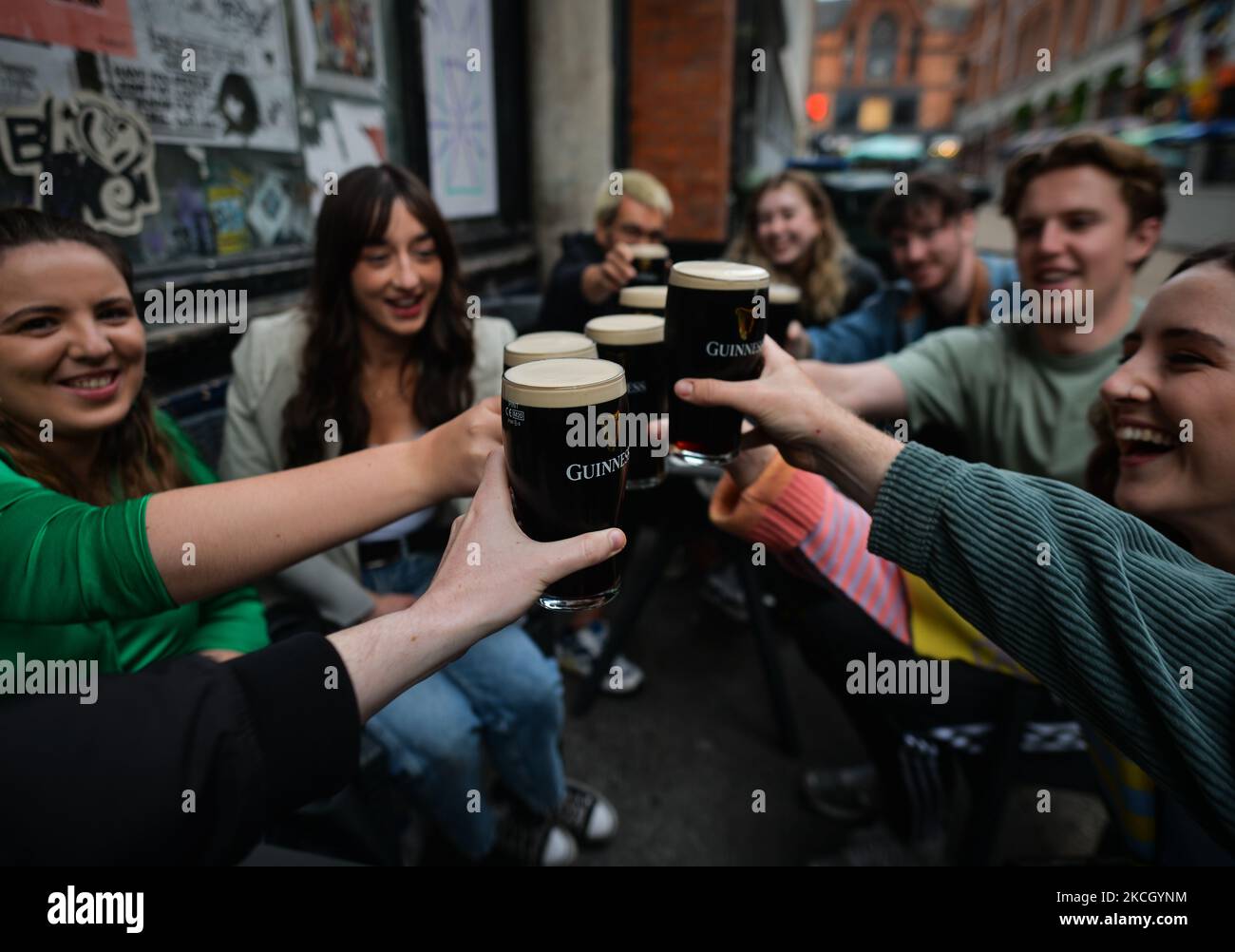 People enjoy drinking Guinness outside a pub in Dublin city center. On ...