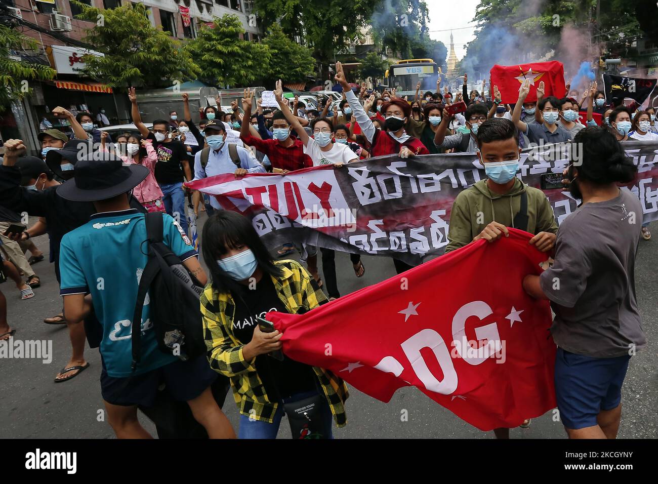 Demonstrators make the three finger salute and hold banners during a ...