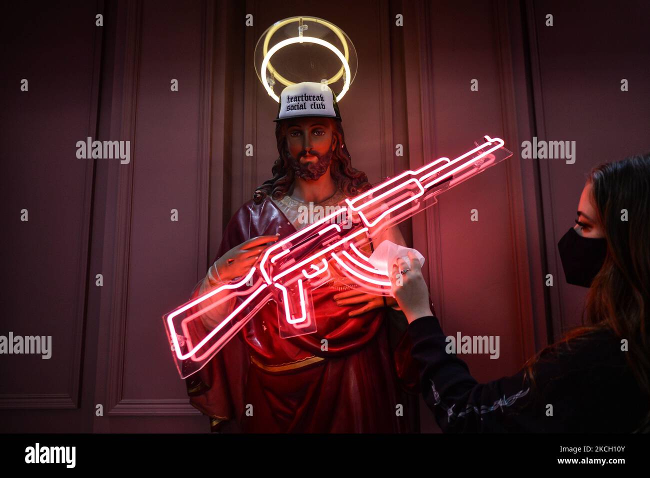 A statue of Jesus holding a neon machine gun inside the Heartbreak ...