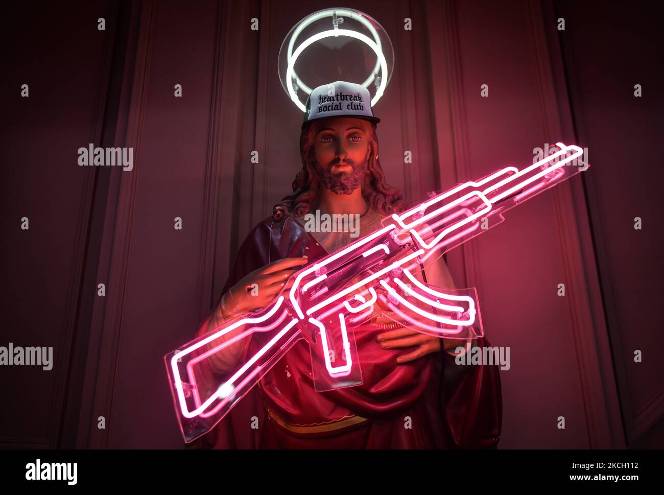 A statue of Jesus holding a neon machine gun inside the Heartbreak ...