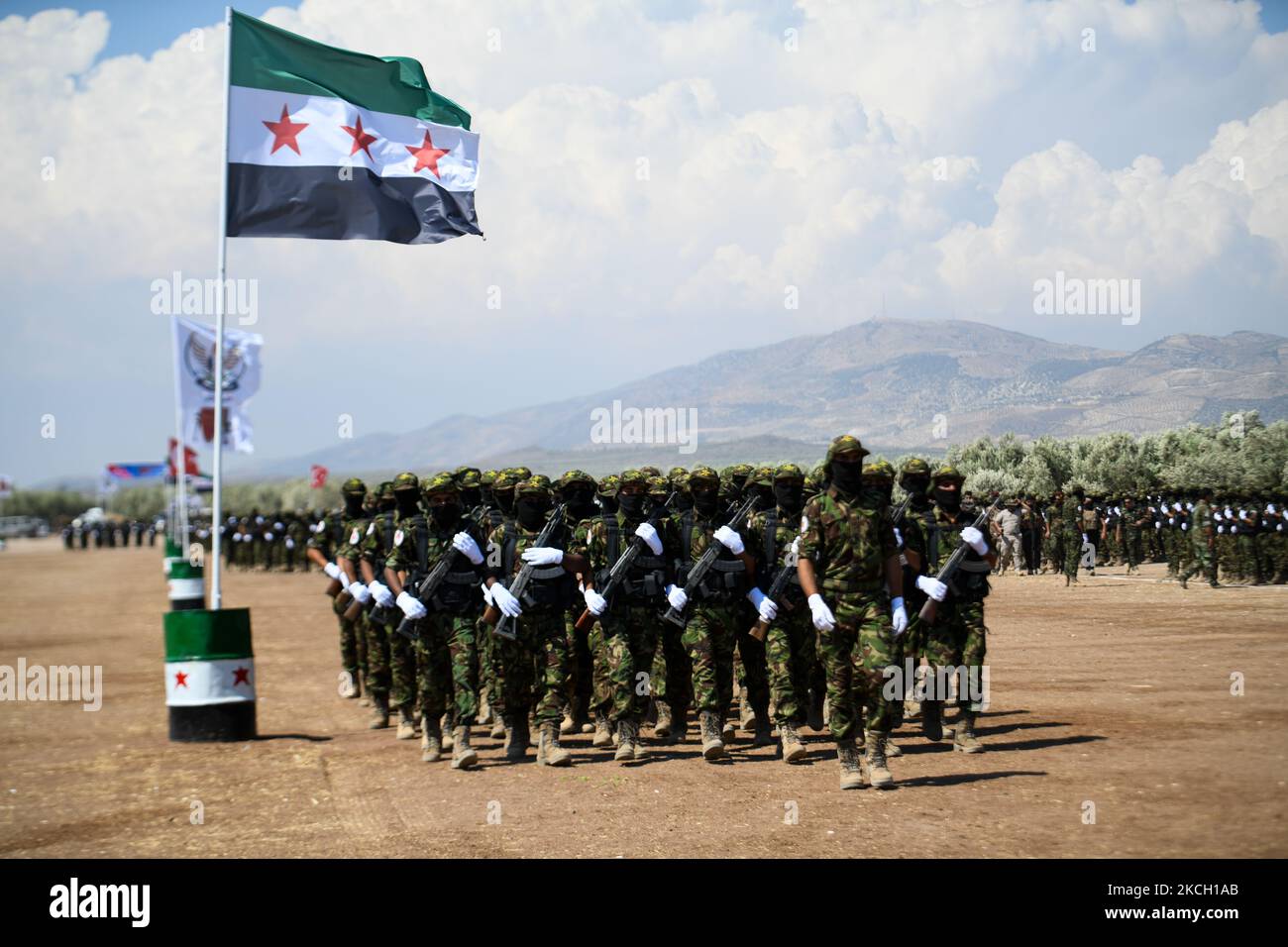 Syrian fighters march in columns, ride dirt bikes and and drive pick-up ...