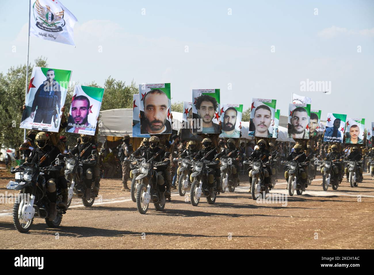 Syrian fighters march in columns, ride dirt bikes and and drive pick-up ...