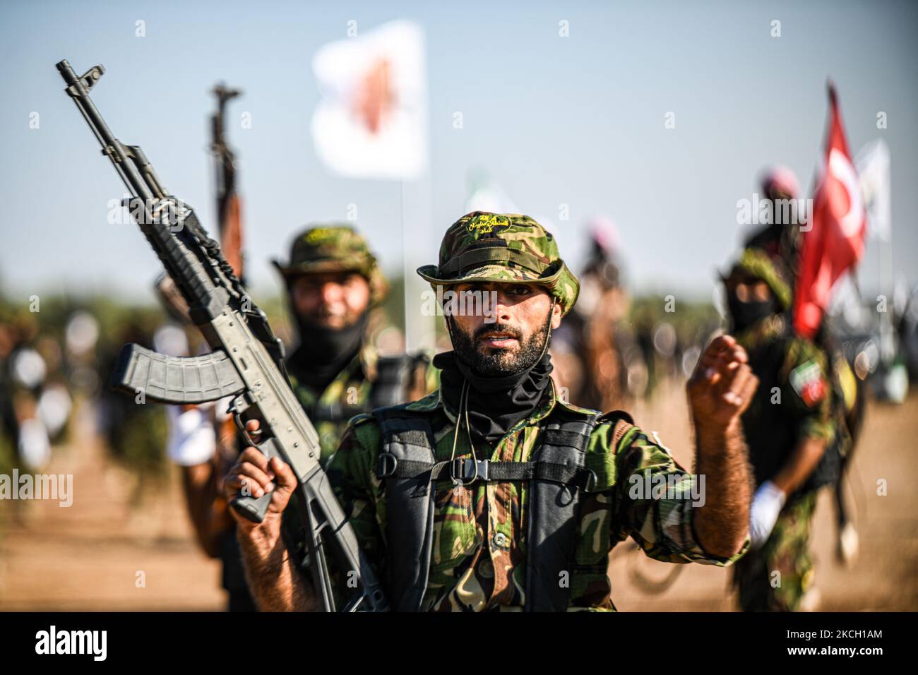 Syrian fighters march in columns, ride dirt bikes and and drive pick-up ...