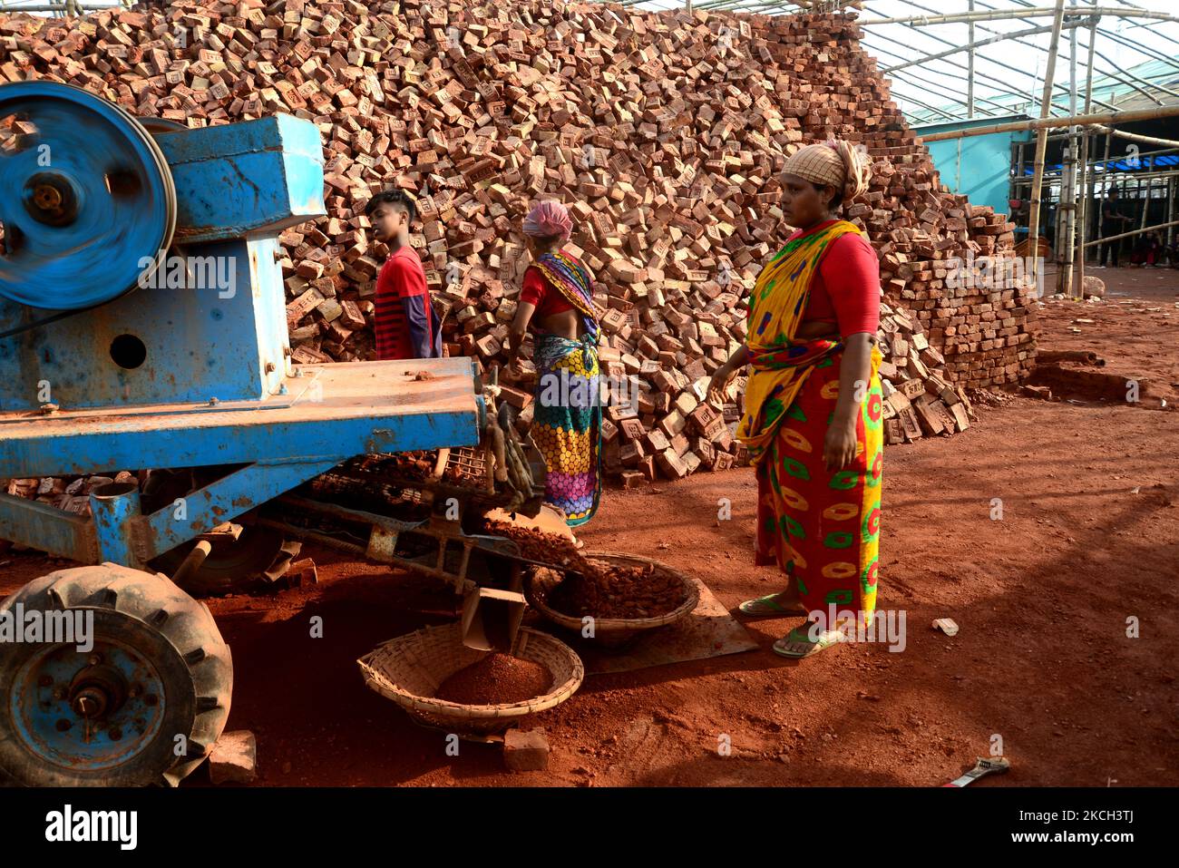 Bangladeshi day labor busy to crushing bricks with a machine during ...