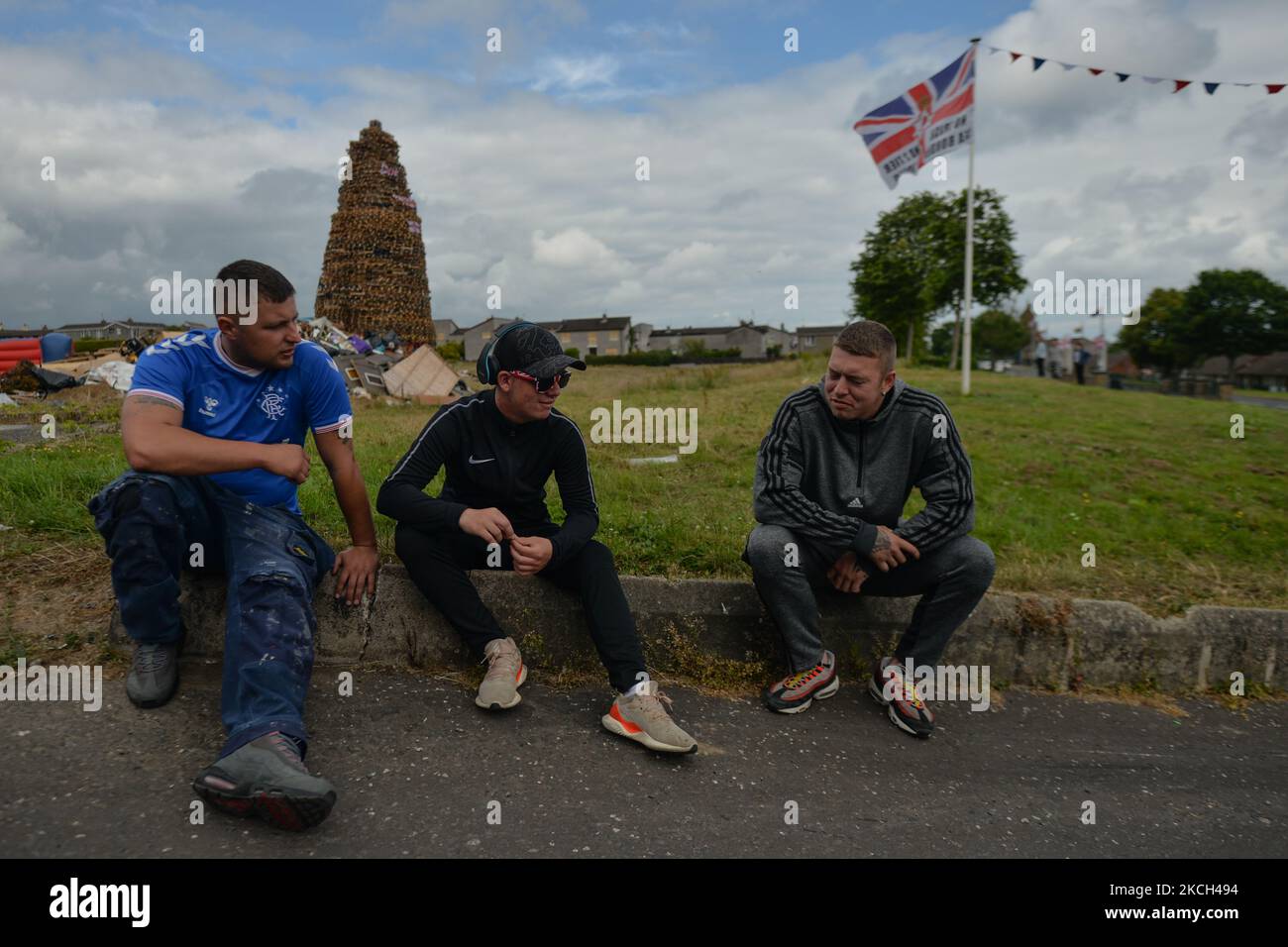 Locals seat near a typical loyalist bonfires made of 156 pallets tall ...