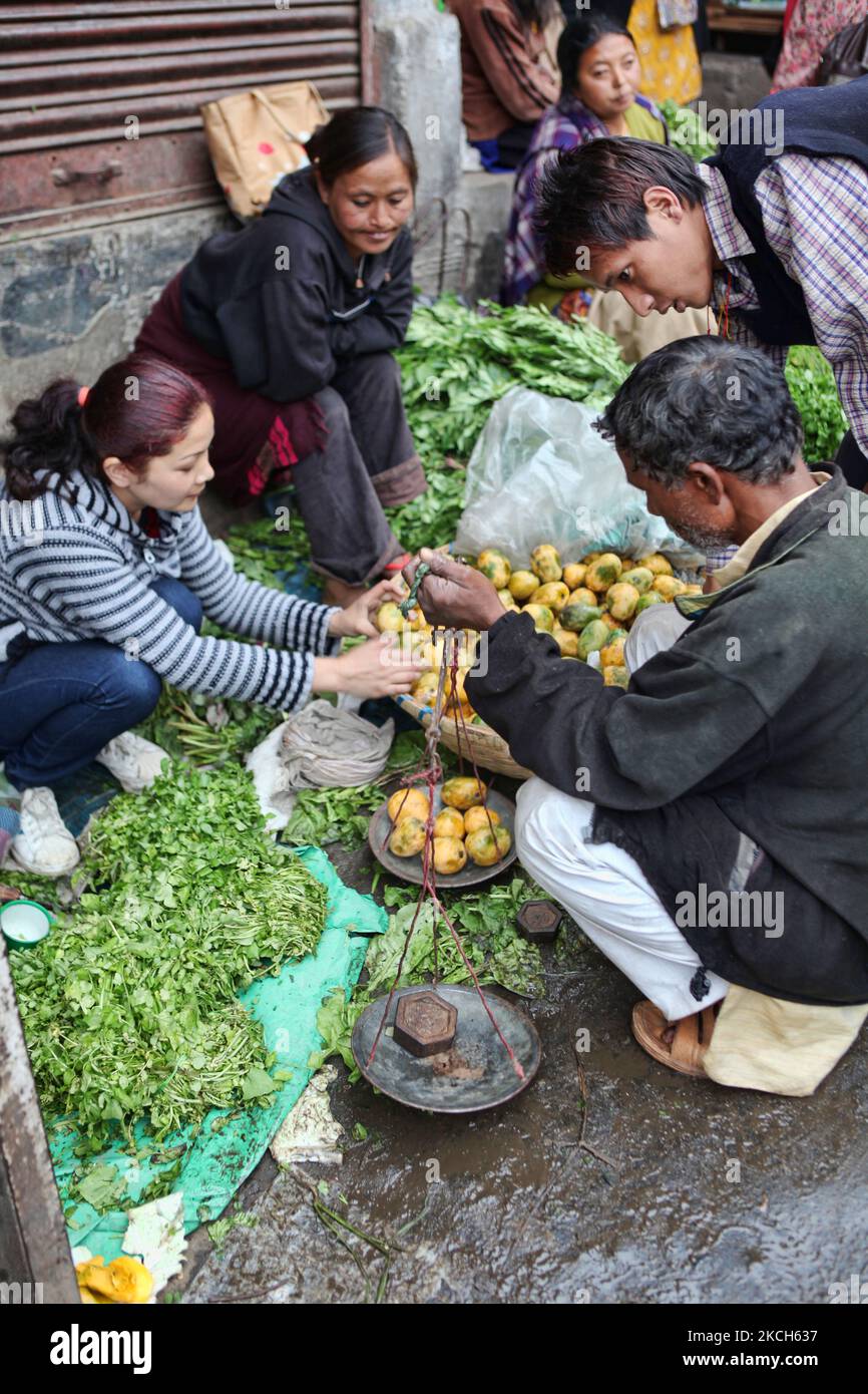 Roadside vendor weighs fresh mangoes on a scale for a customer in ...
