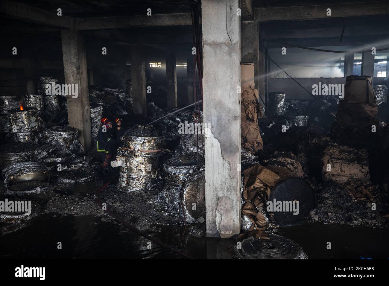 Firefighter's and rescue workers works inside the burned factory ...