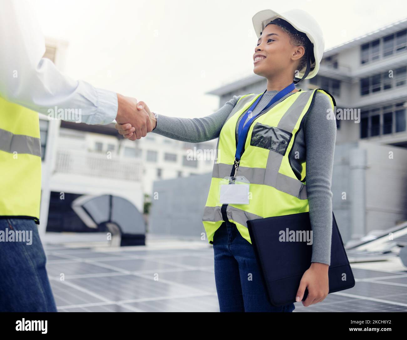 Engineering team handshake, black woman at solar panel construction ...