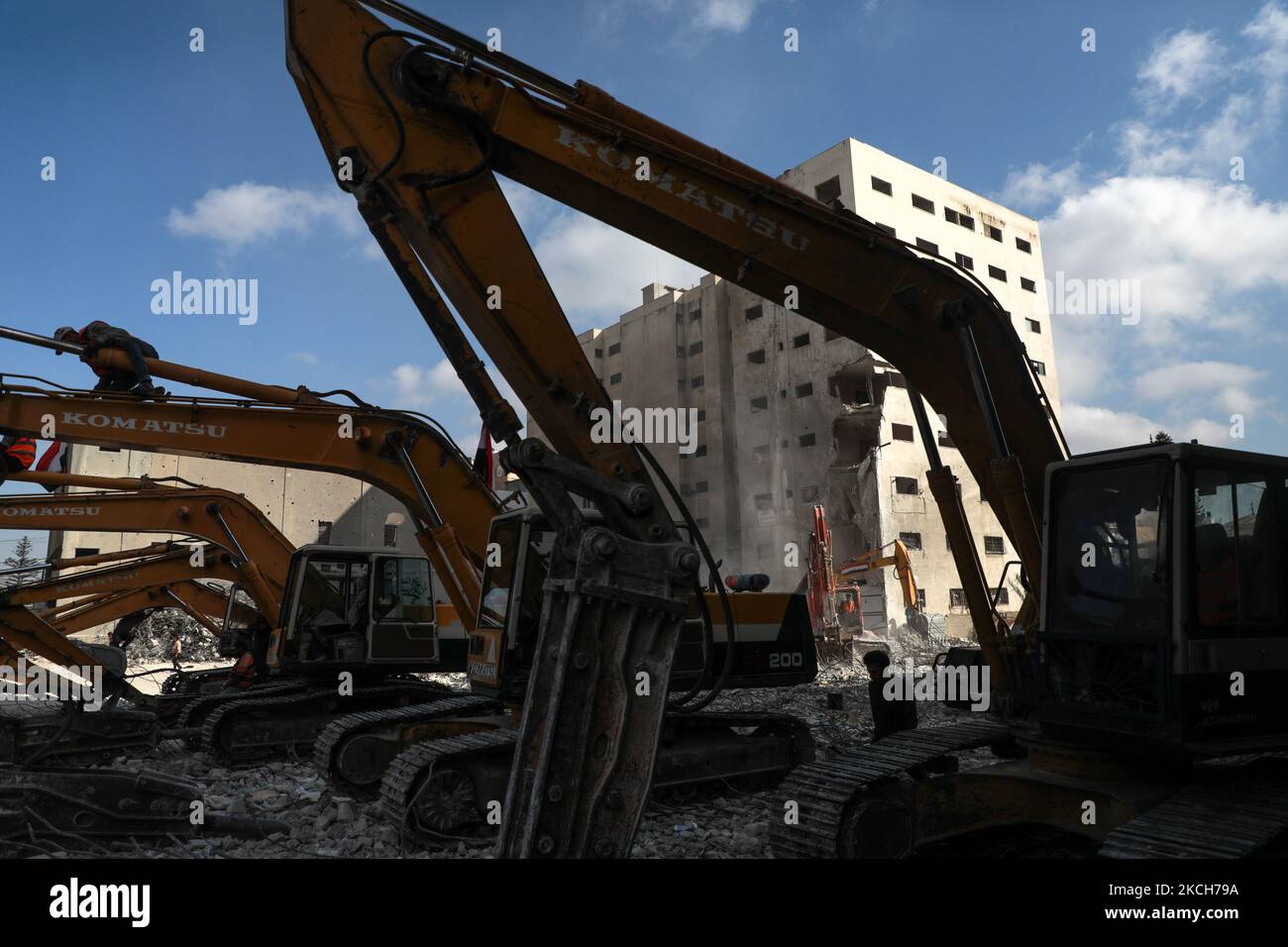 Palestinian workers collect the rubble of Al-Jalaa tower, levelled by ...