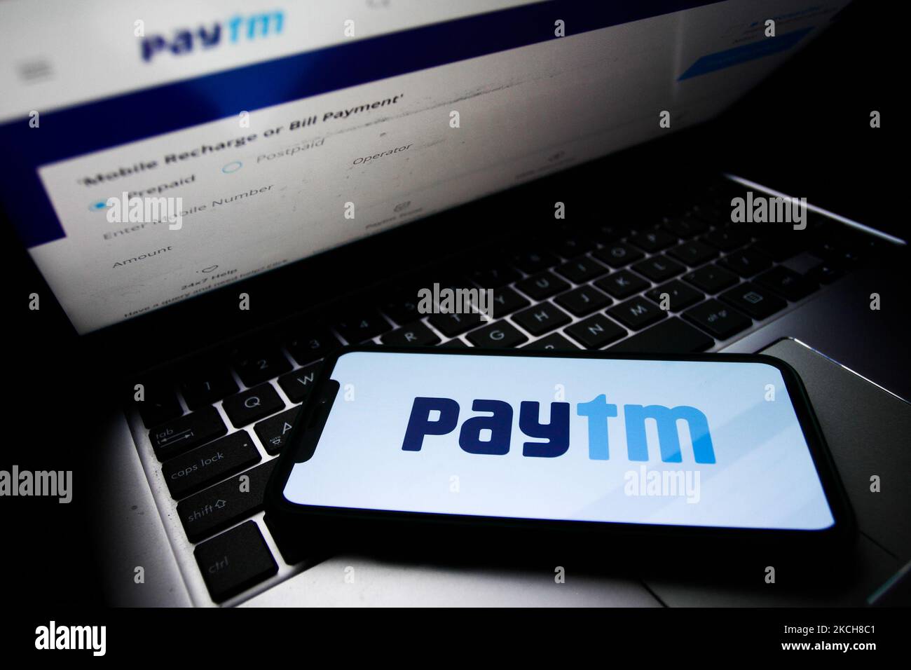 Paytm logo displayed on a phone screen and Paytm website displayed on a ...