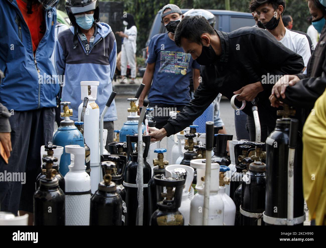 Residents gather to get oxygen tanks refill at an oxygen refill shop in ...