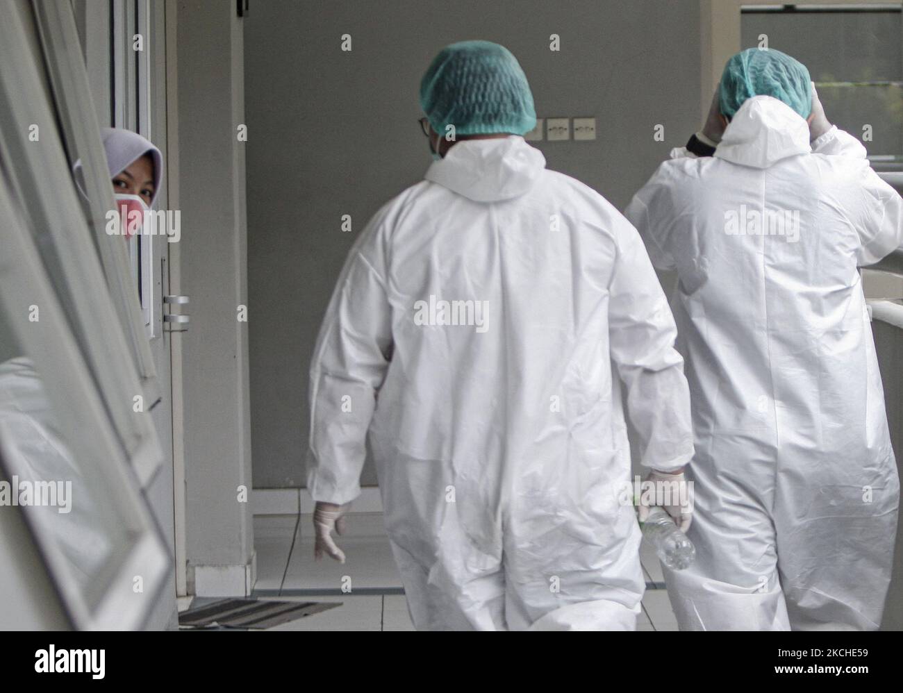 Health worker wearing Personal Protective Equipment (PPE) walk at a ...