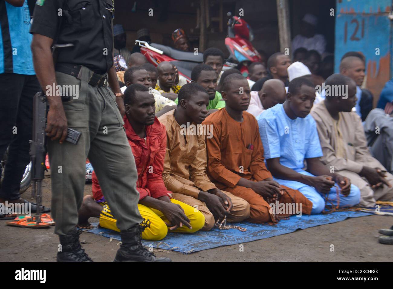 A security official stand on guard with a gun as Muslim devotees take ...