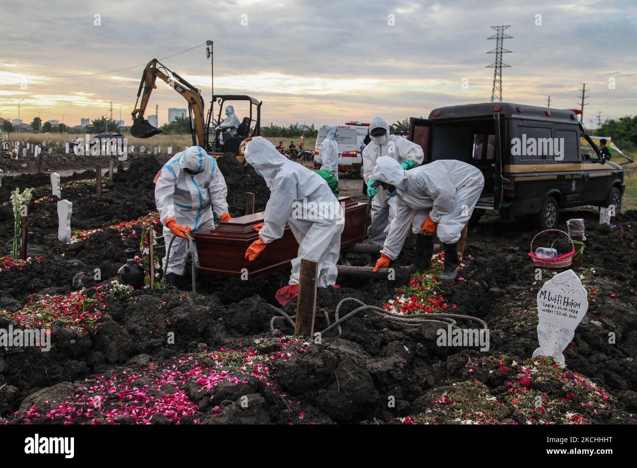 Funeral workers carry a coffin at the burial site for the Covid-19 ...