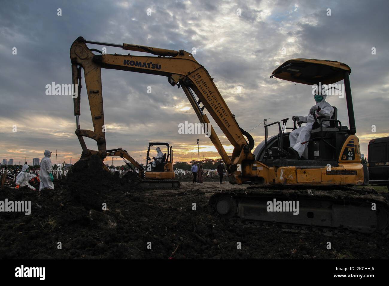 funeral workers digging graves at the burial site for the Covid-19 ...