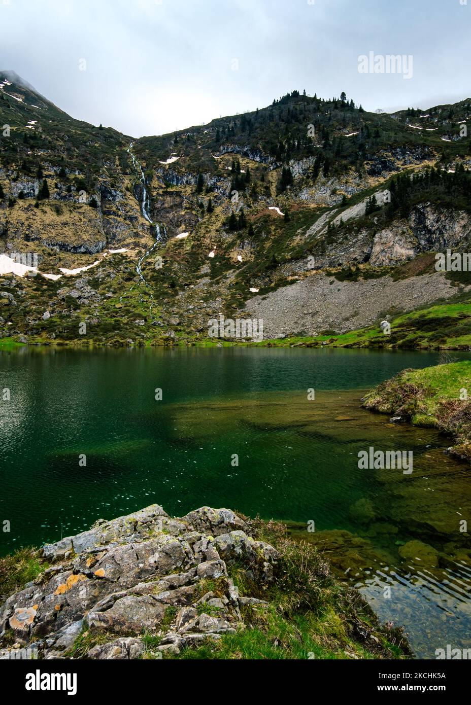 View on the beautiful blue lake of Ayes, with a waterfall, the pastures ...