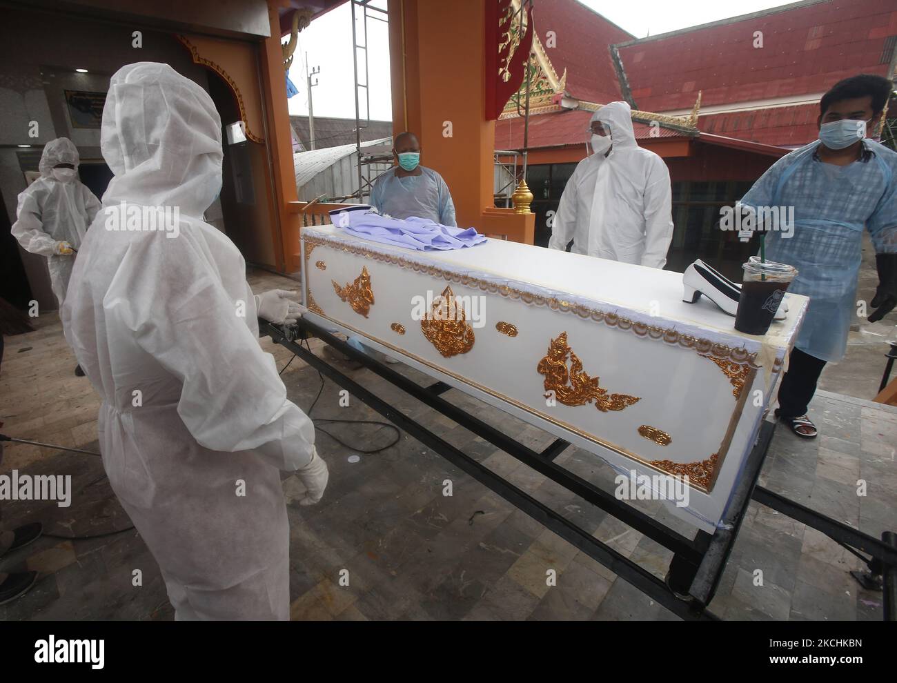 Temple workers wearing personal protective equipment suites (PPE) stand ...