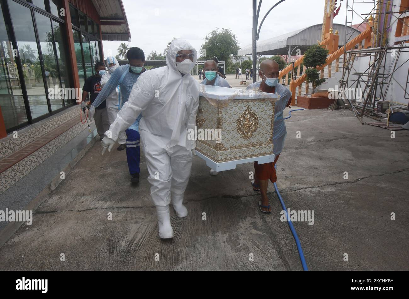 Temple workers wearing personal protective equipment suites (PPE) carry ...