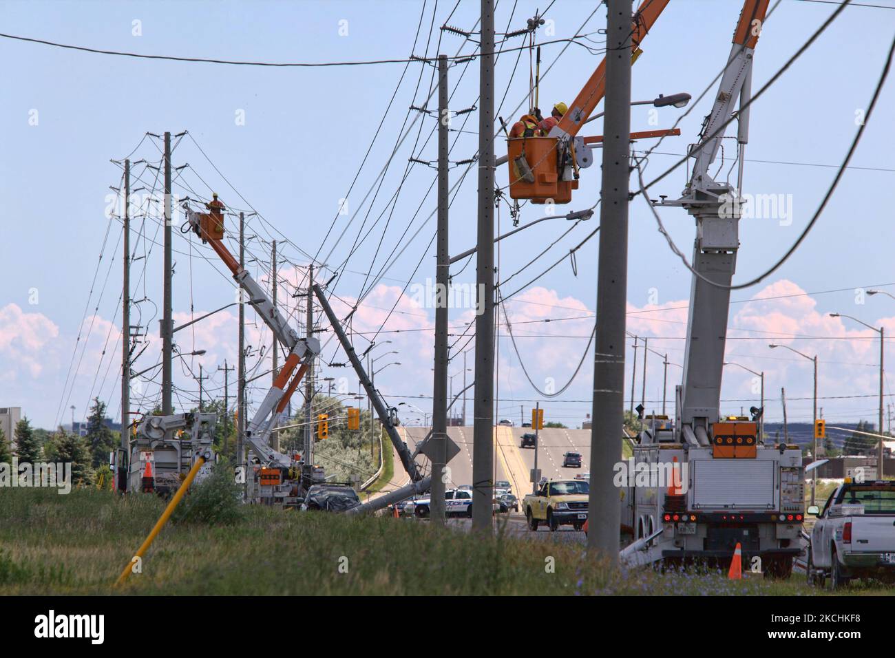 Workers repair a damaged utility pole and electrical transformer after ...