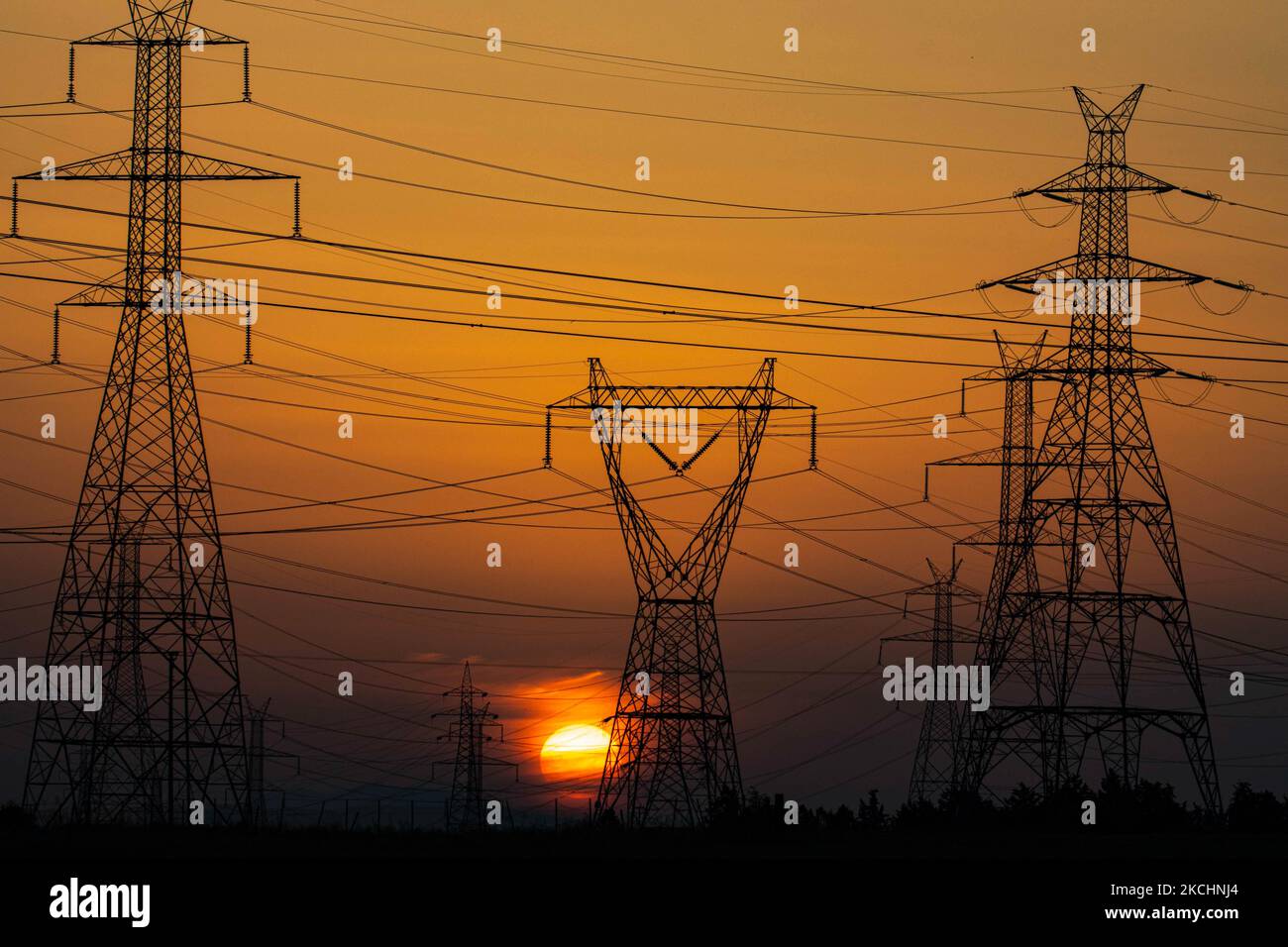 Summer sunset in Greece with electrical pylons near Thessaloniki city ...