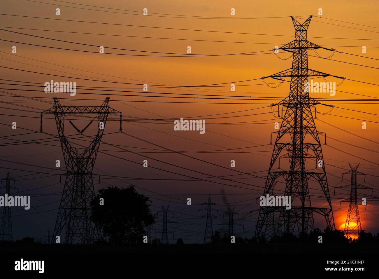 Summer sunset in Greece with electrical pylons near Thessaloniki city ...
