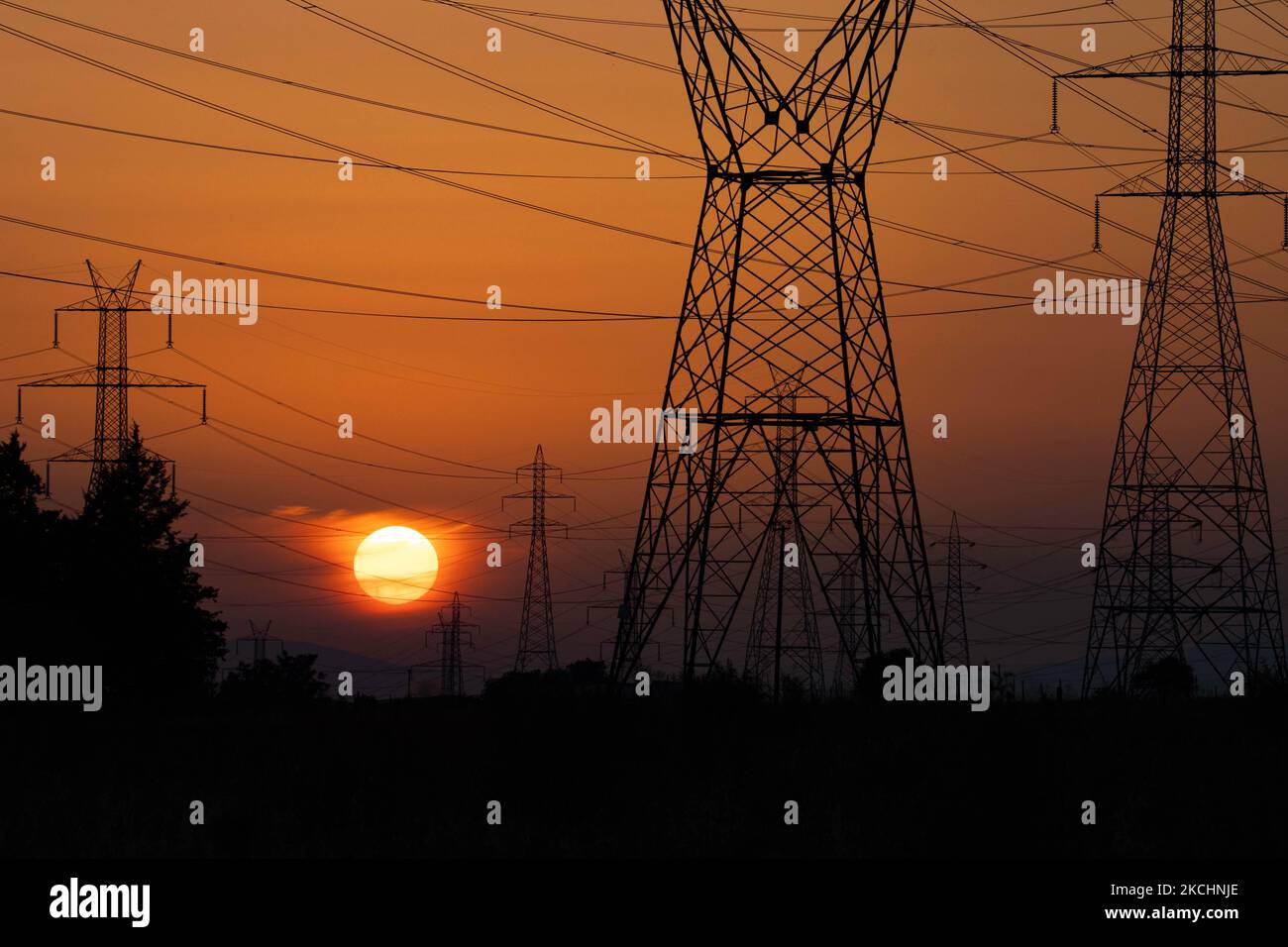 Summer sunset in Greece with electrical pylons near Thessaloniki city ...
