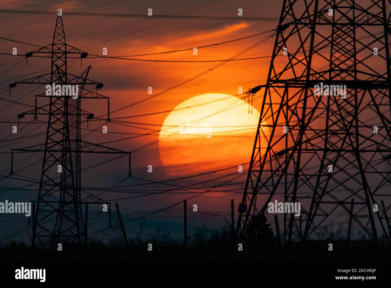 Summer sunset in Greece with electrical pylons near Thessaloniki city ...