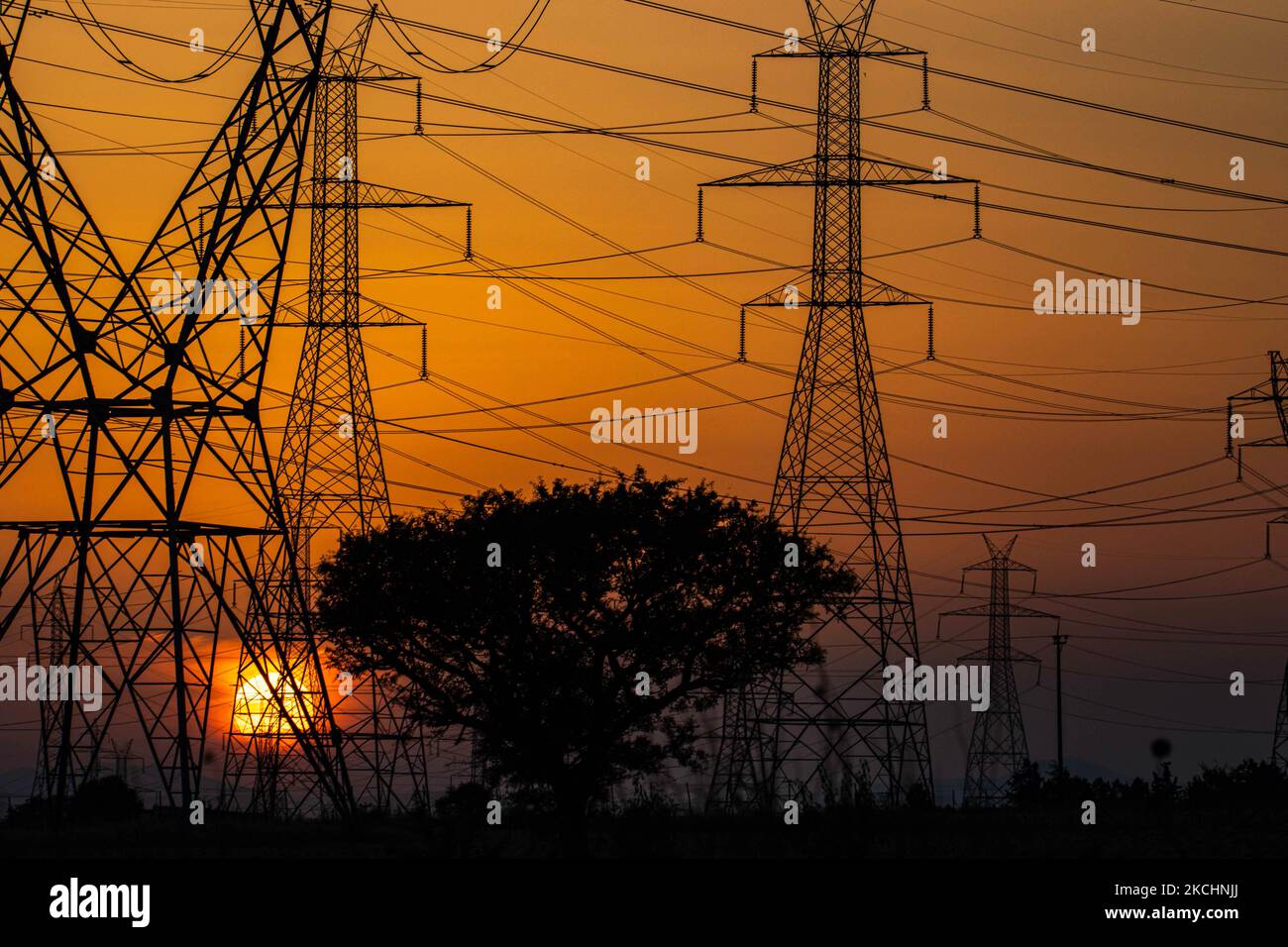 Summer sunset in Greece with electrical pylons near Thessaloniki city ...