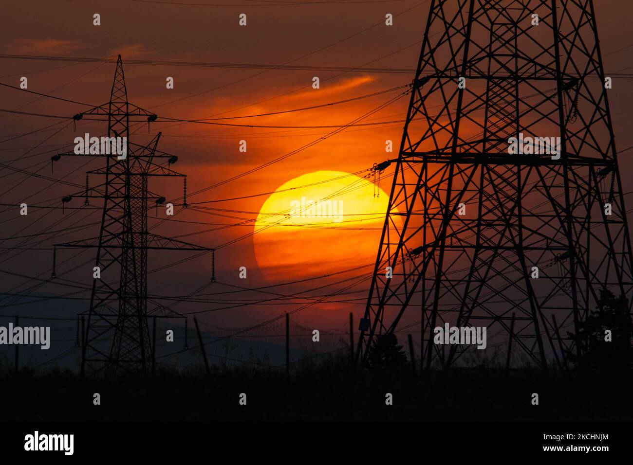 Summer sunset in Greece with electrical pylons near Thessaloniki city ...