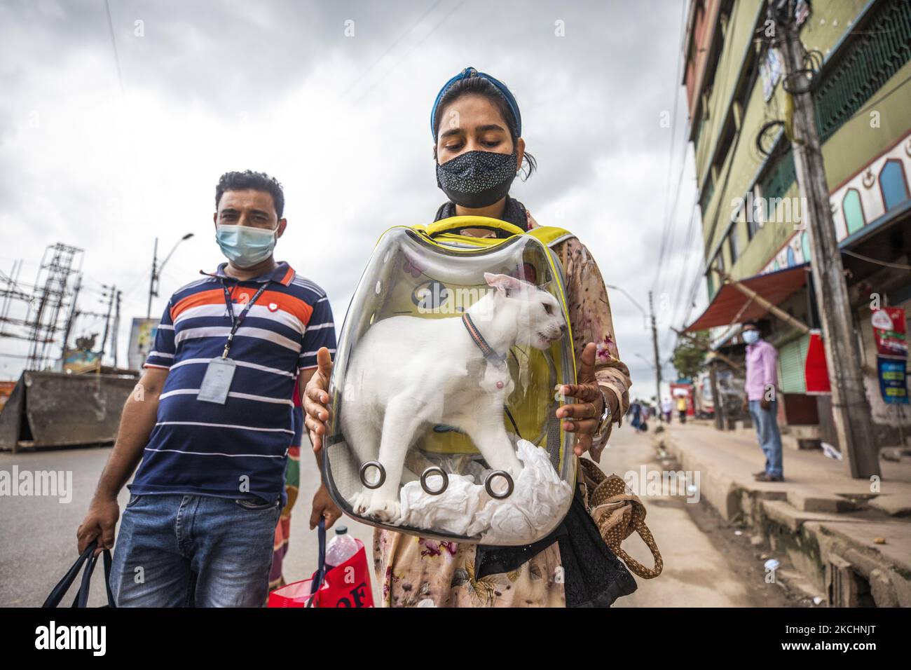 Aivin walks towards her home with her pet Zozo in Dhaka on July 23 ...