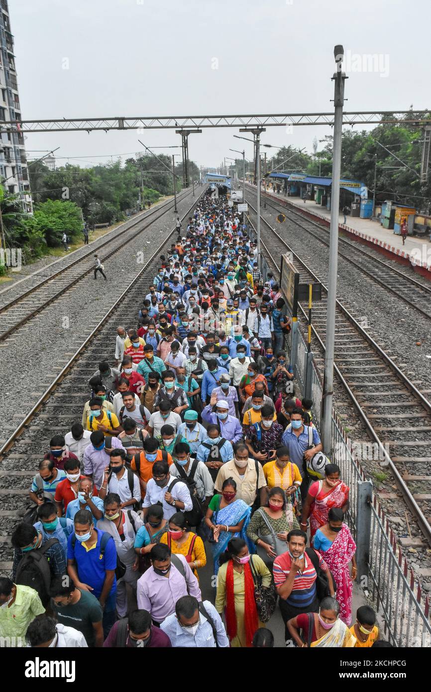 A large number queue of commuters is seen walking along a platform ...