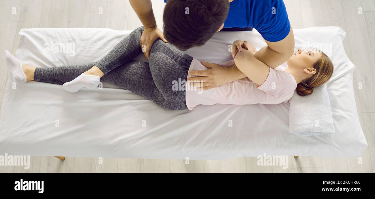 Male physiotherapist provides physical assistance to female patient ...