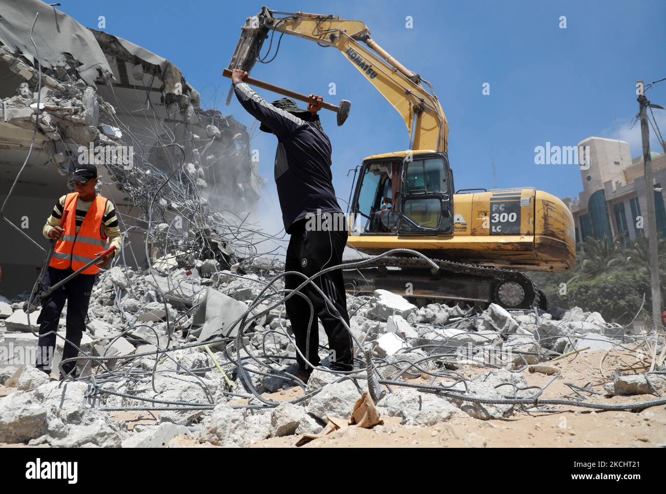 Palestinian workers clear the rubble of buildings, leveled by Israeli ...