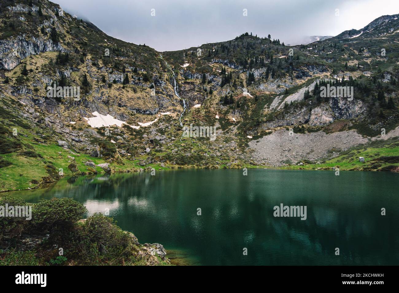 View on the beautiful blue lake of Ayes, with a waterfall, the pastures ...