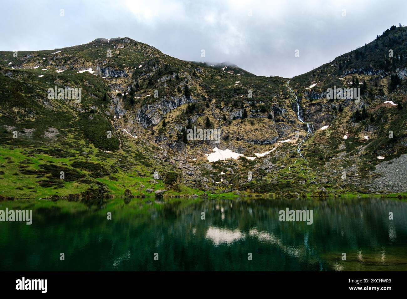 View on the beautiful blue lake of Ayes, with a waterfall, the pastures ...