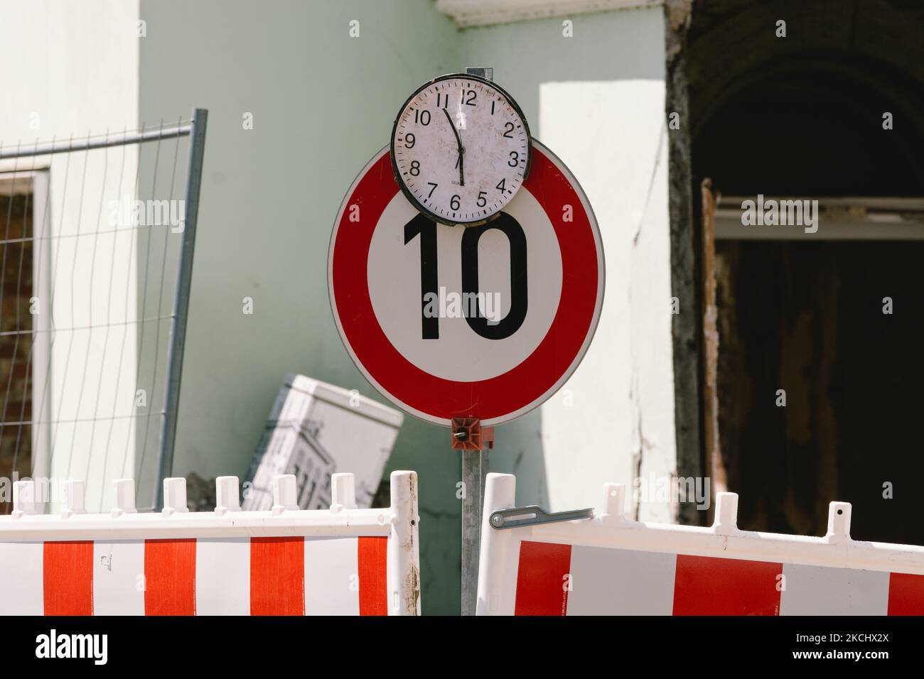 a clock is seen stopped on top pf a traffic speed sign in Stolberg ...