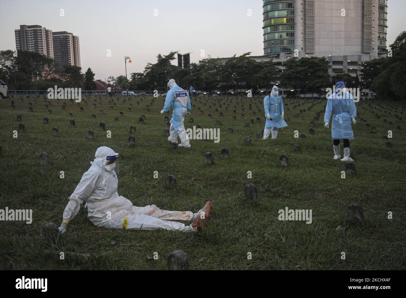 Health worker take a break while burying the body of a Covid-19 victim ...