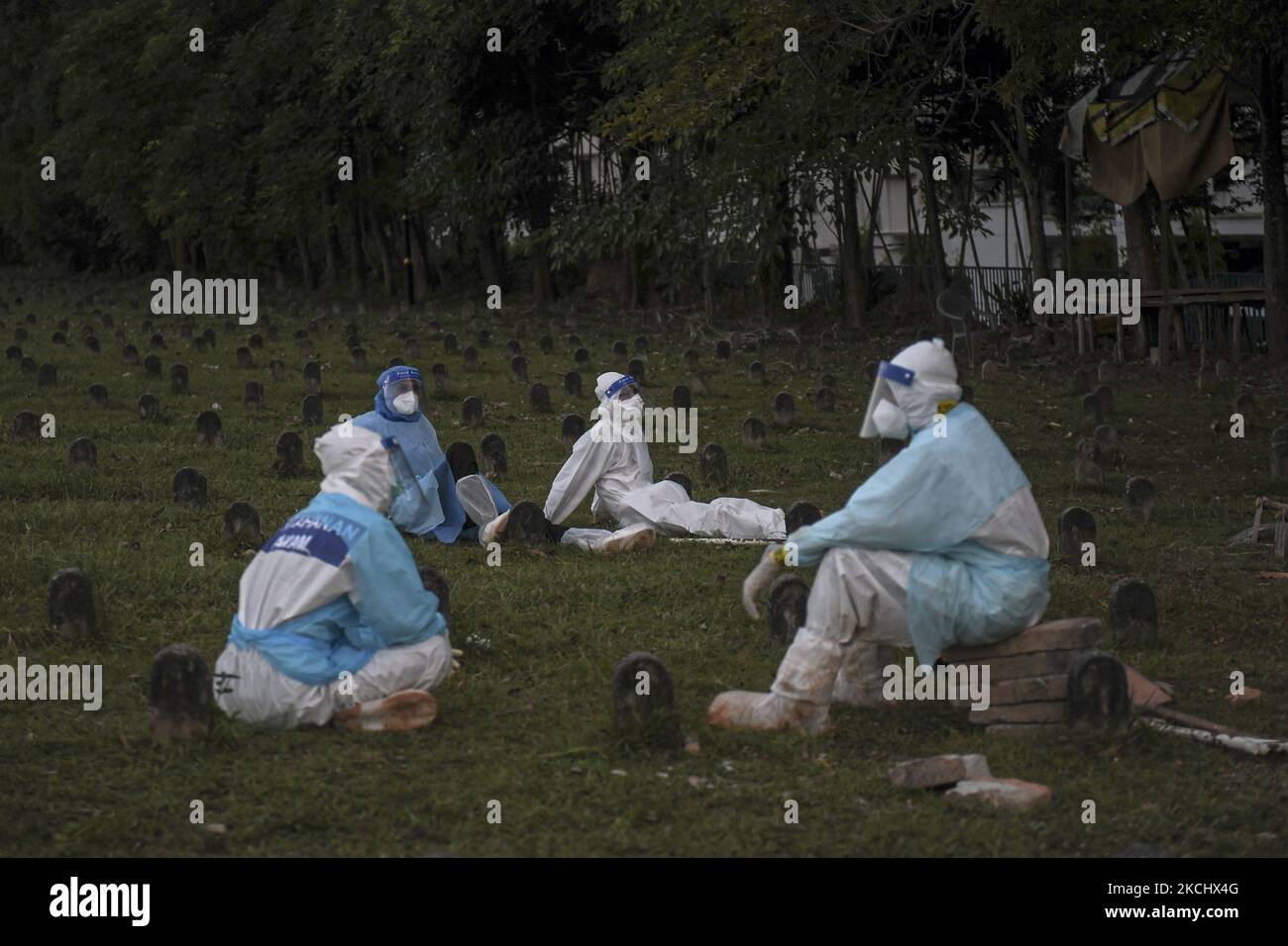 Health worker take a break while burying the body of a Covid-19 victim ...
