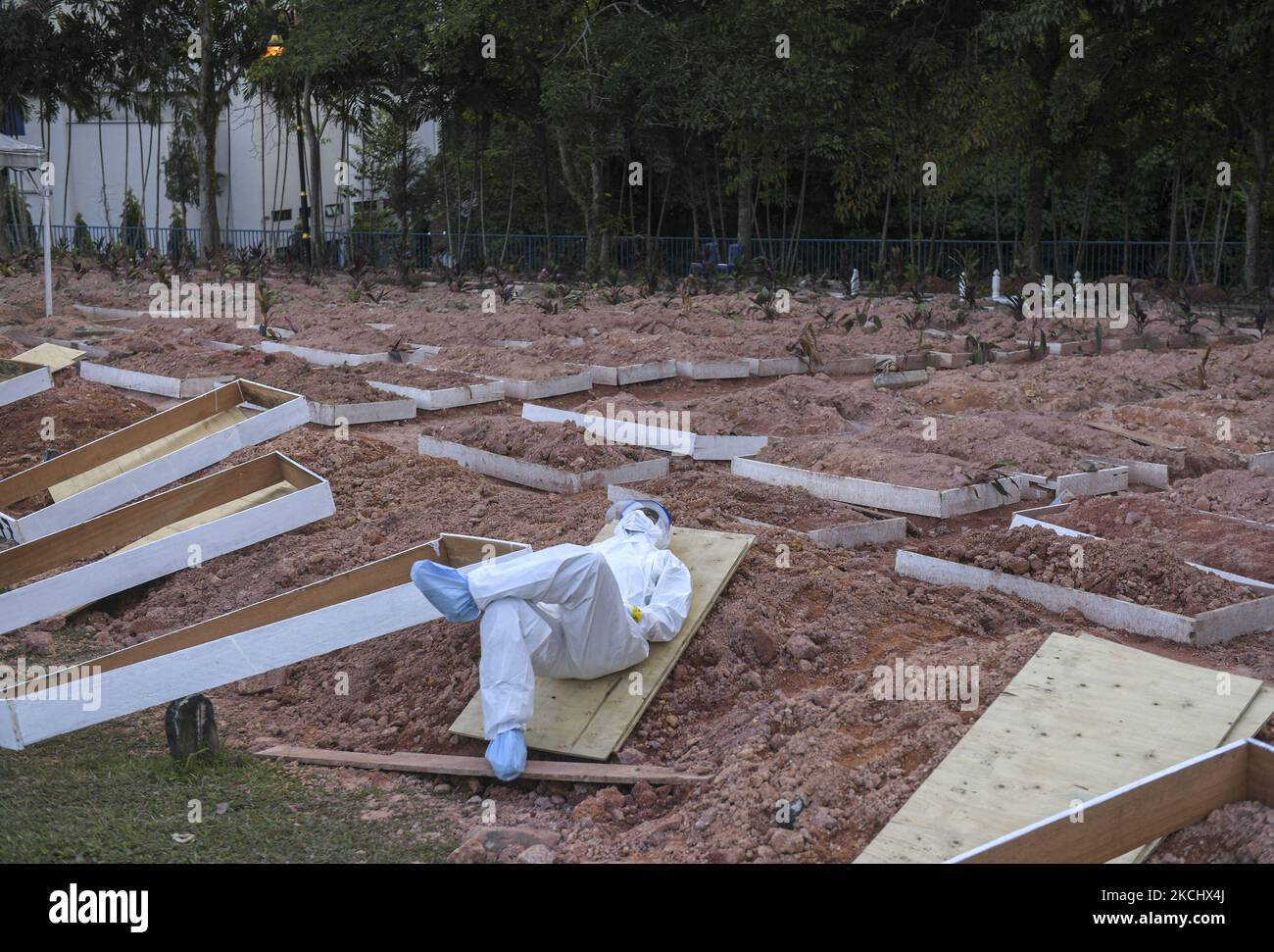 Health worker take a break while burying the body of a Covid-19 victim ...