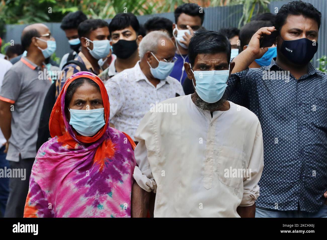 People wait in a queue for the COVID-19 vaccine at a hospital in Dhaka, Bangladesh on July 28 ...