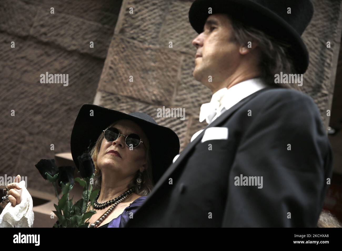 People in costume walk behind artist Anne-Katrin Spiess as she is ...