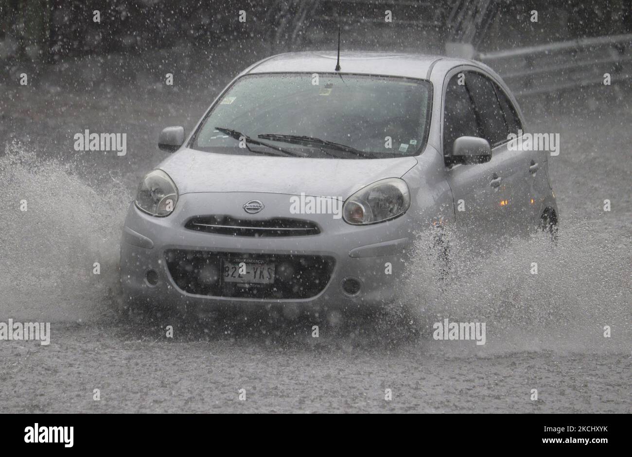 A car in heavy rain in Mexico City where there were several puddles in ...