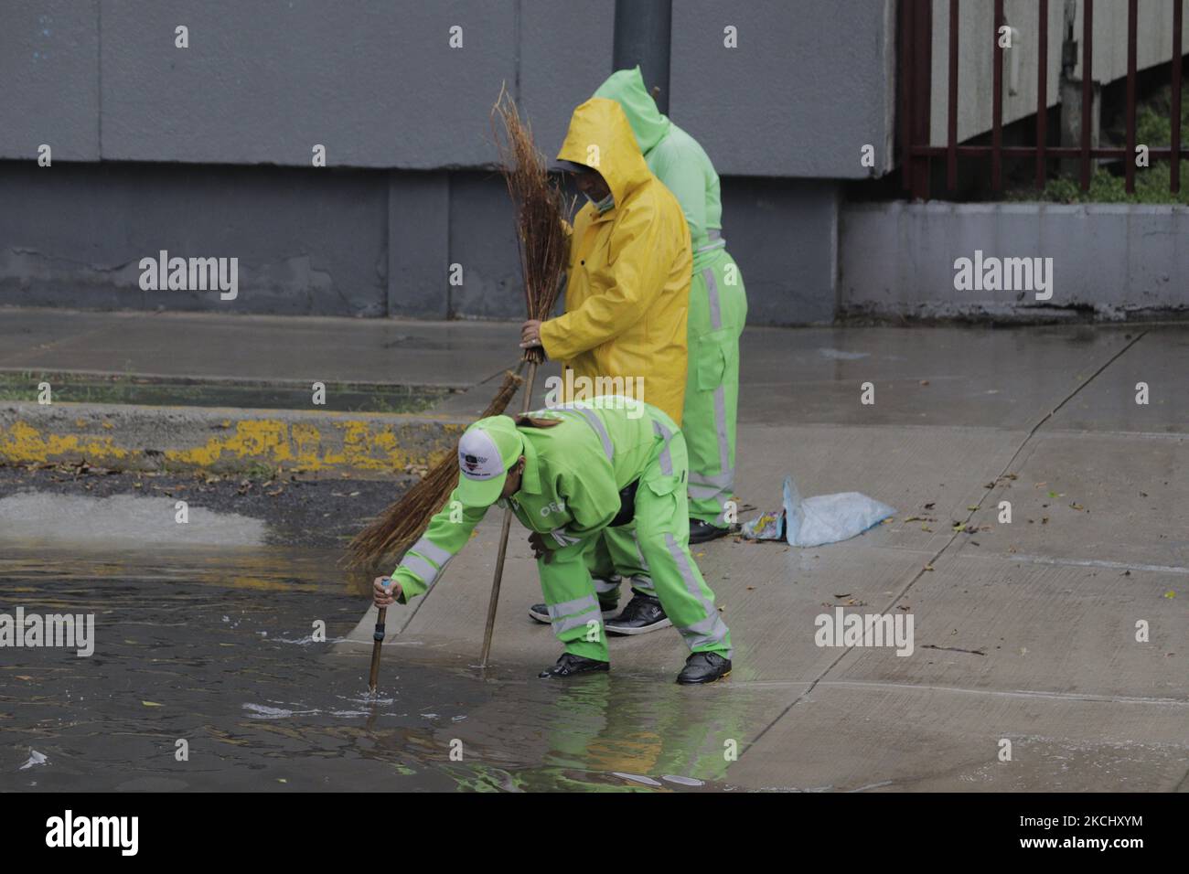 Cleaning workers uncover drains under heavy rain in Mexico City where ...