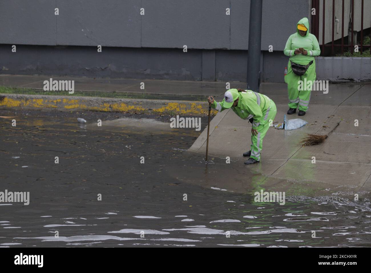 Cleaning workers uncover drains under heavy rain in Mexico City where ...