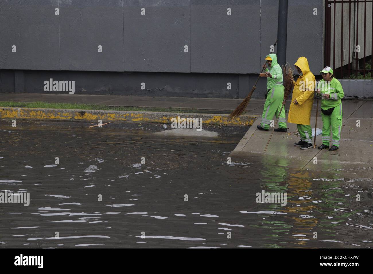 Cleaning workers uncover drains under heavy rain in Mexico City where ...