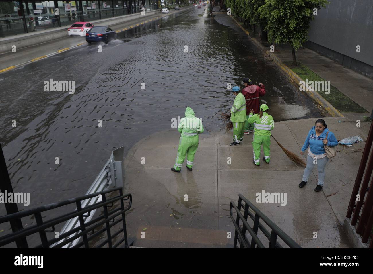 Cleaning workers uncover drains under heavy rain in Mexico City where ...