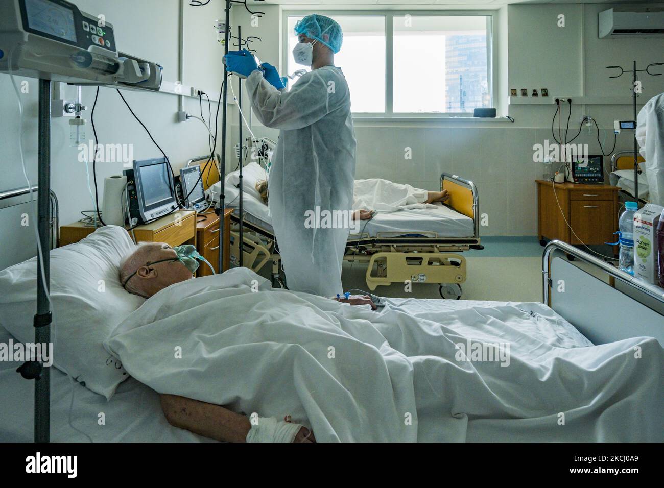 A doctor adjusts the breathing assistant devices of patients with ...