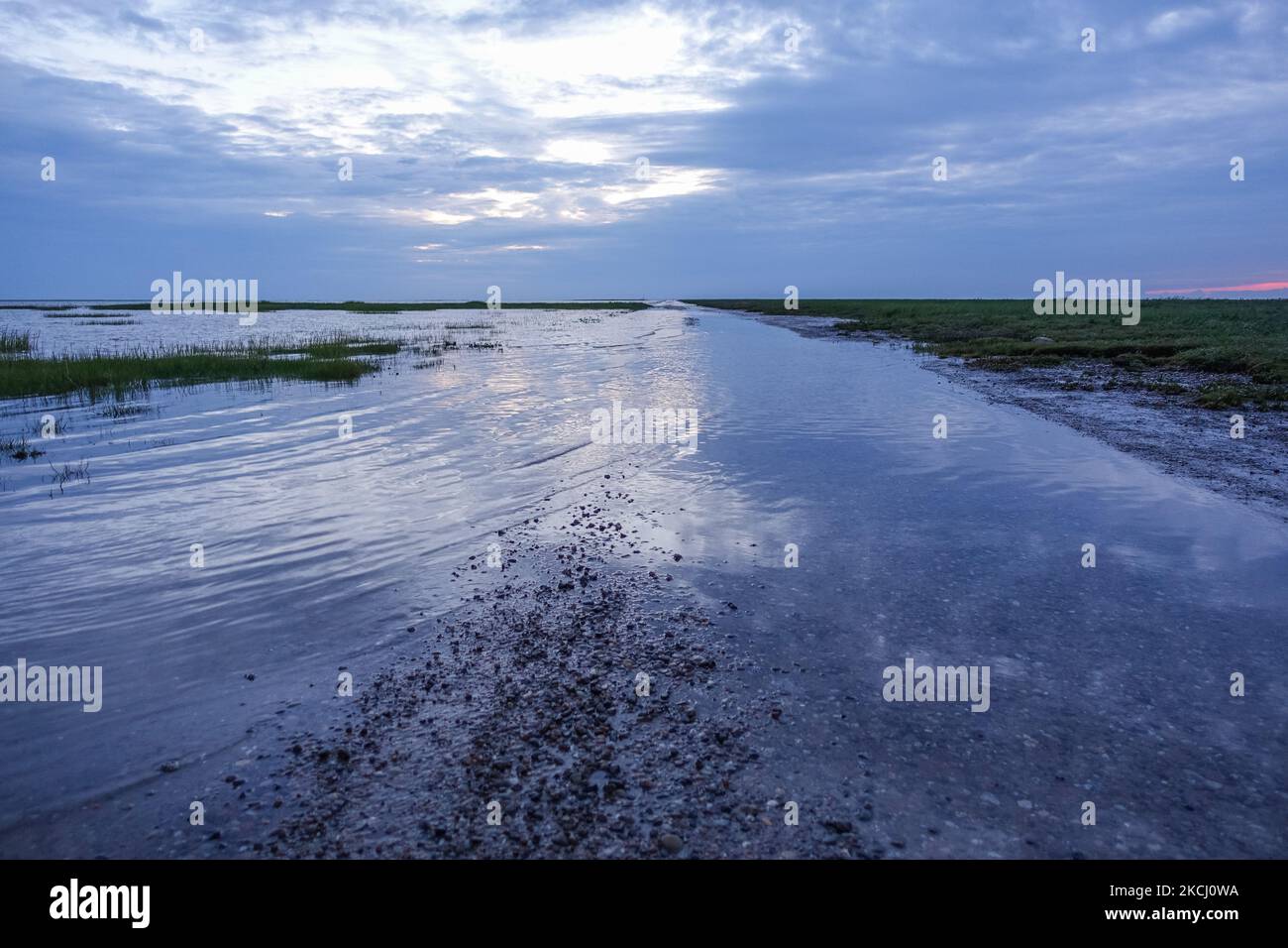High tide covering the only road to get to the Mando Island is seen in ...