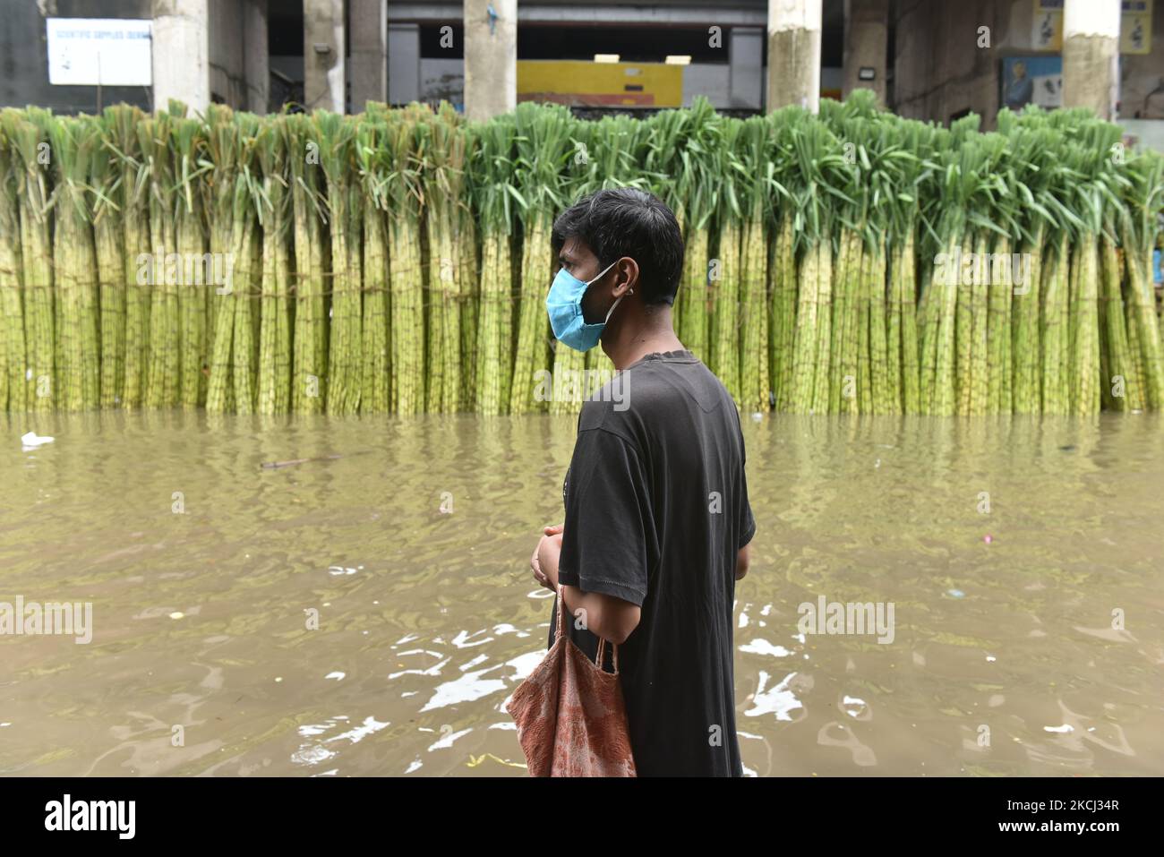 People wade through a waterlogged street in Kolkata, India, on July 30 ...