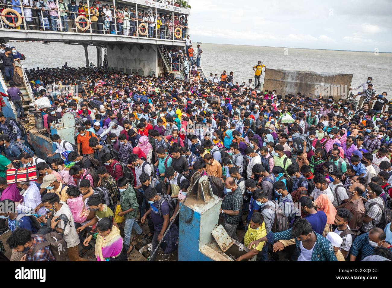 Dhaka bound people disembark from a ferry in Sreenagar on July 31, 2021 ...